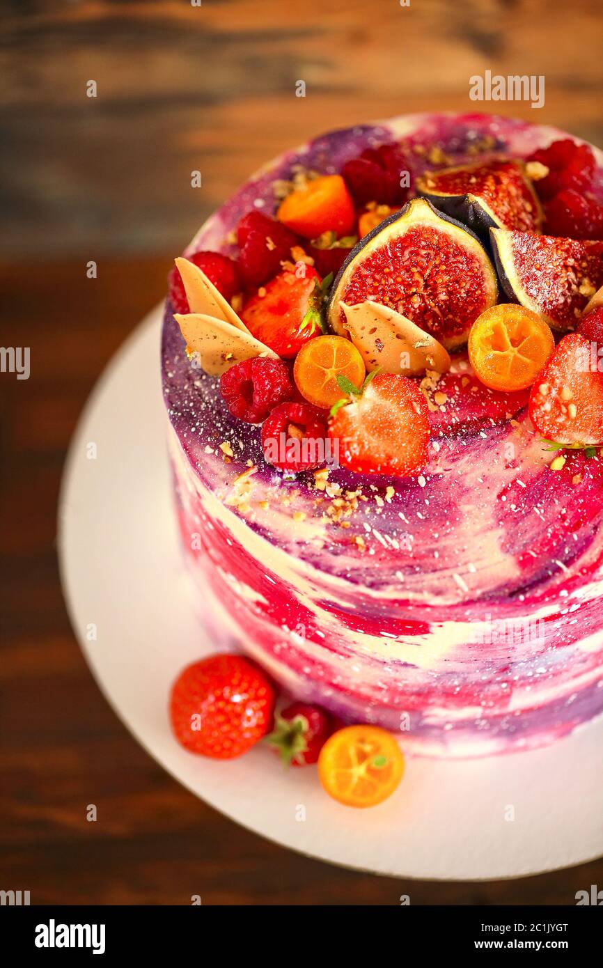 Beautiful bright cake on a porcelain cake stand decorated with fruits ...
