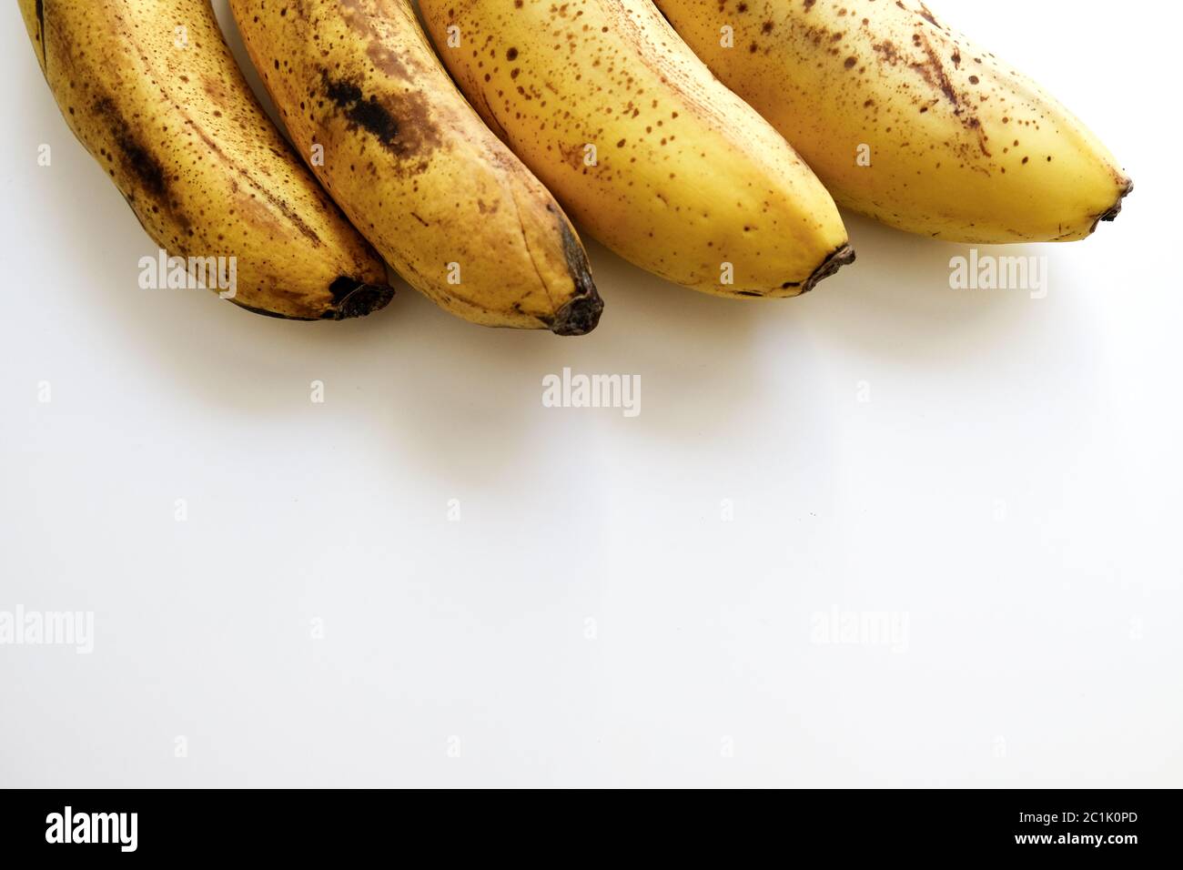 Bunch of overripe bananas in a row on the top. White space for copy ...