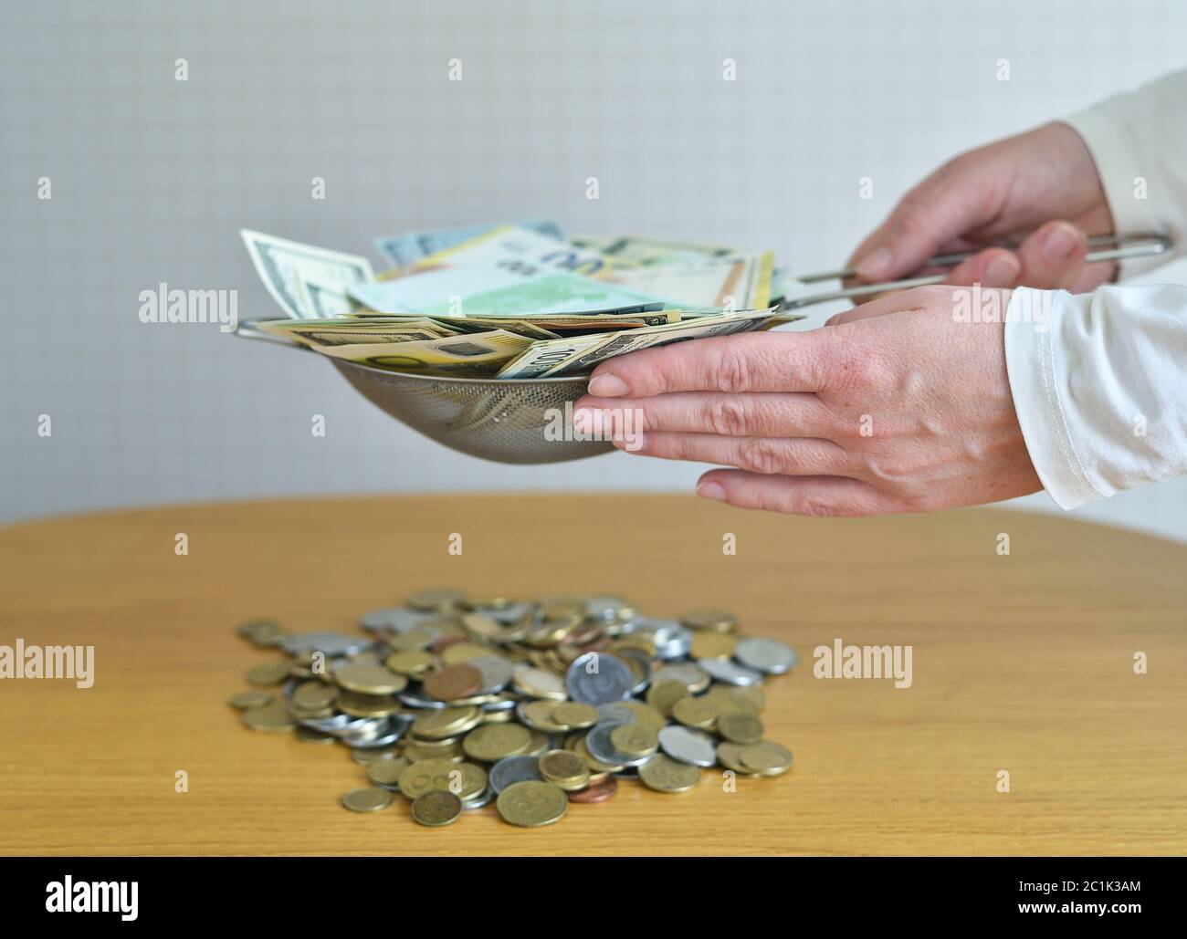 Coins falling through hand hi-res stock photography and images - Alamy