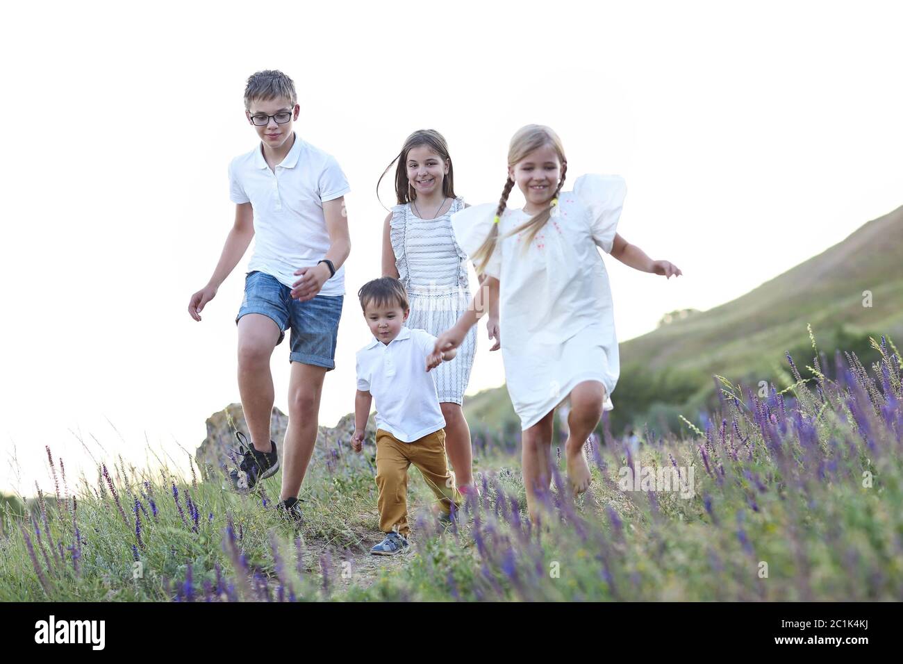 Kids running in the summer medow Stock Photo - Alamy