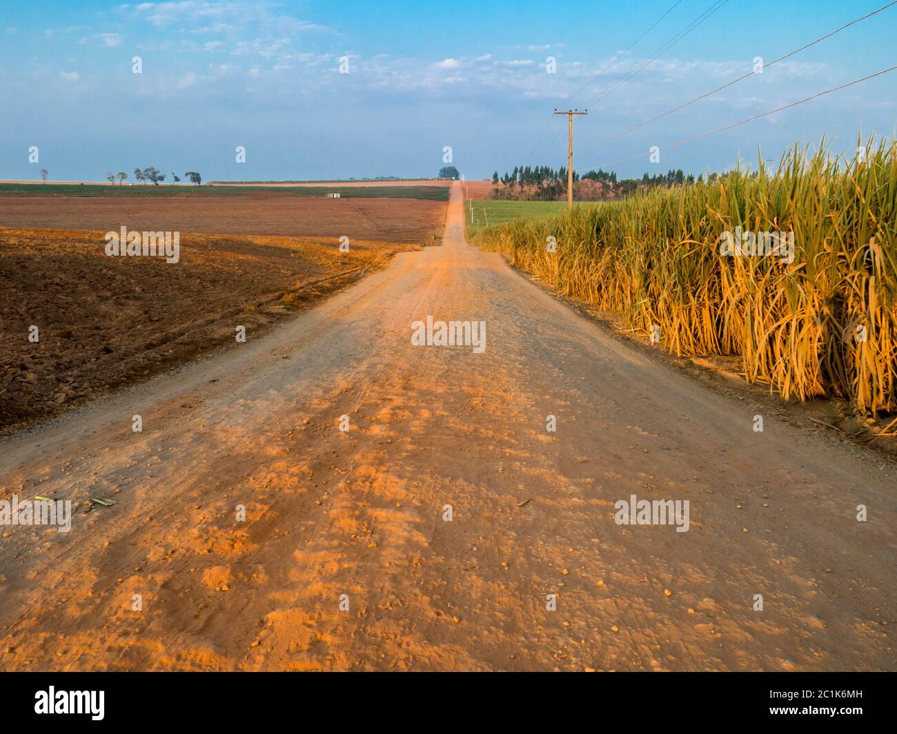 Rural orange dirt road with blue sky and far horizon Stock Photo - Alamy