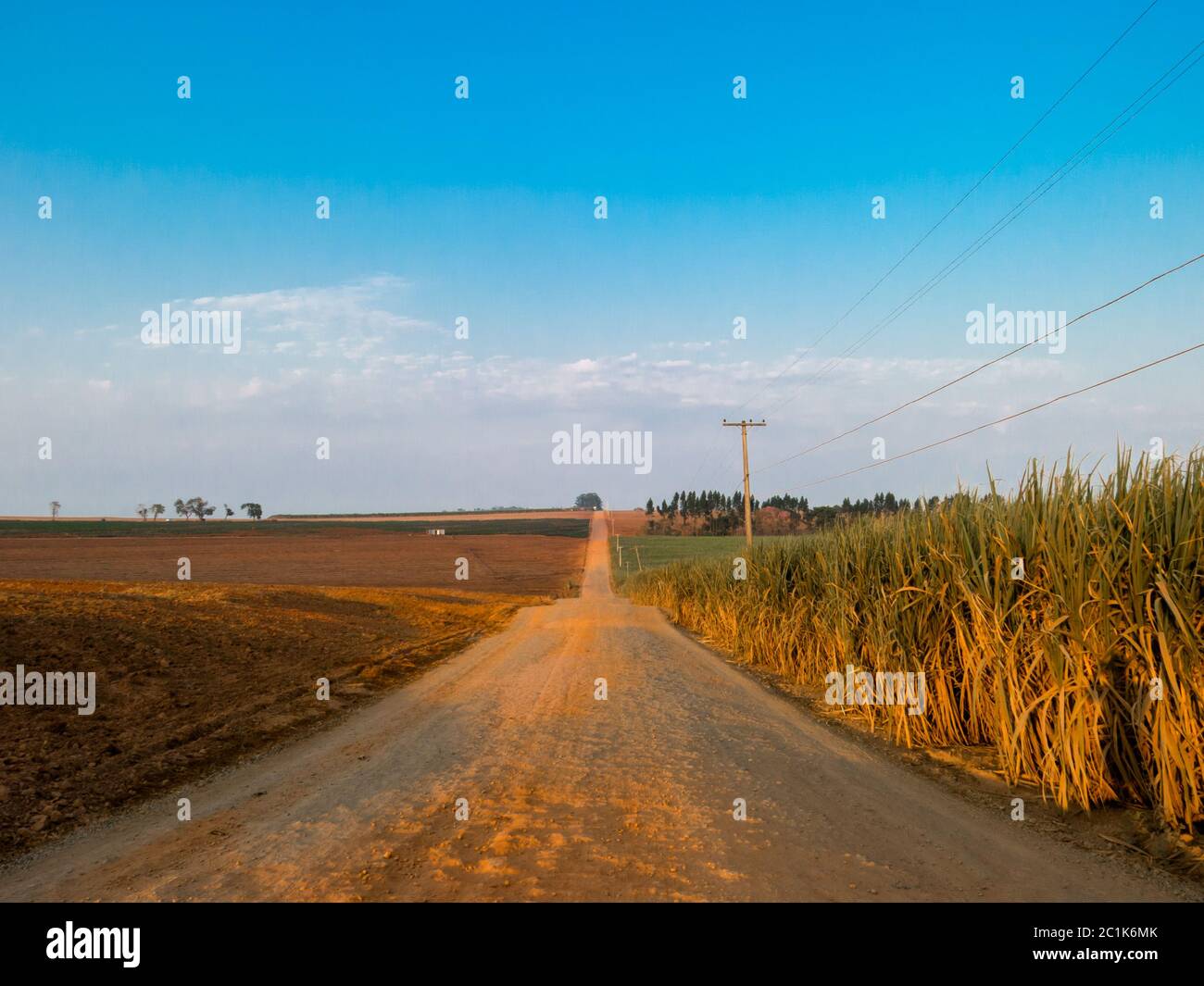 Rural orange dirt road with blue sky and far horizon Stock Photo - Alamy