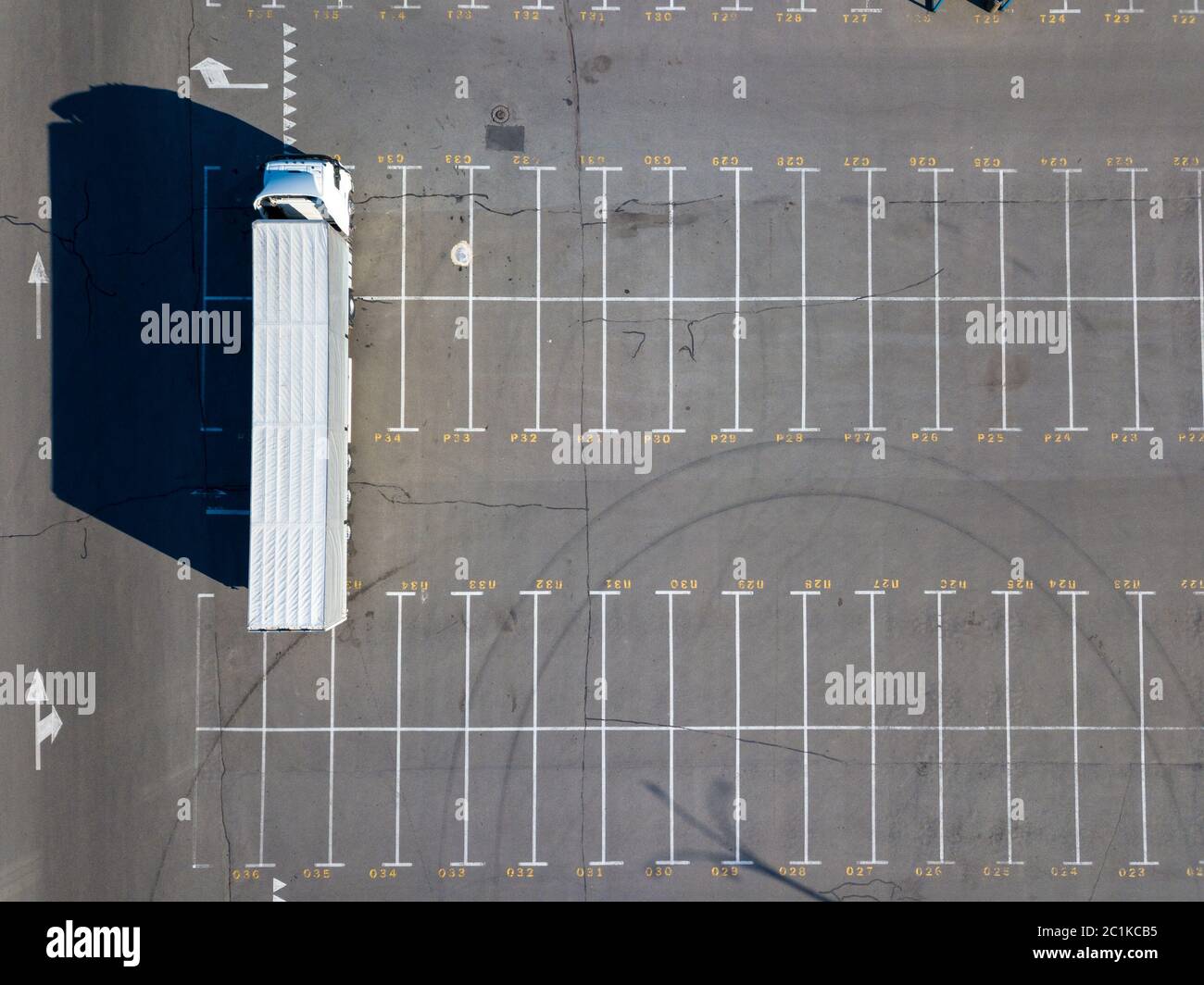 A long truck in a parking lot with markings for loading with building ...
