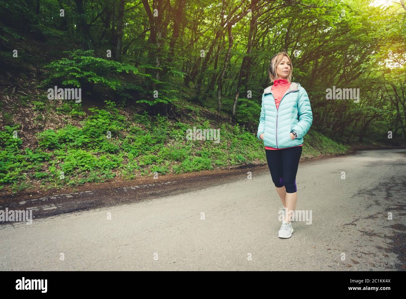 Portrait of an attractive sports girl blonde in a light running down ...