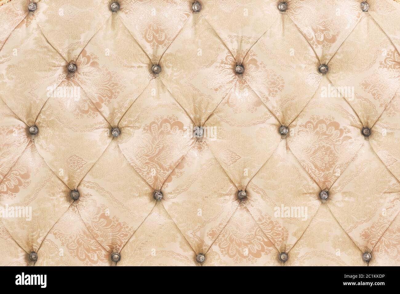 Beige soft tapestry pattern background with symmetrical buttons on the ...