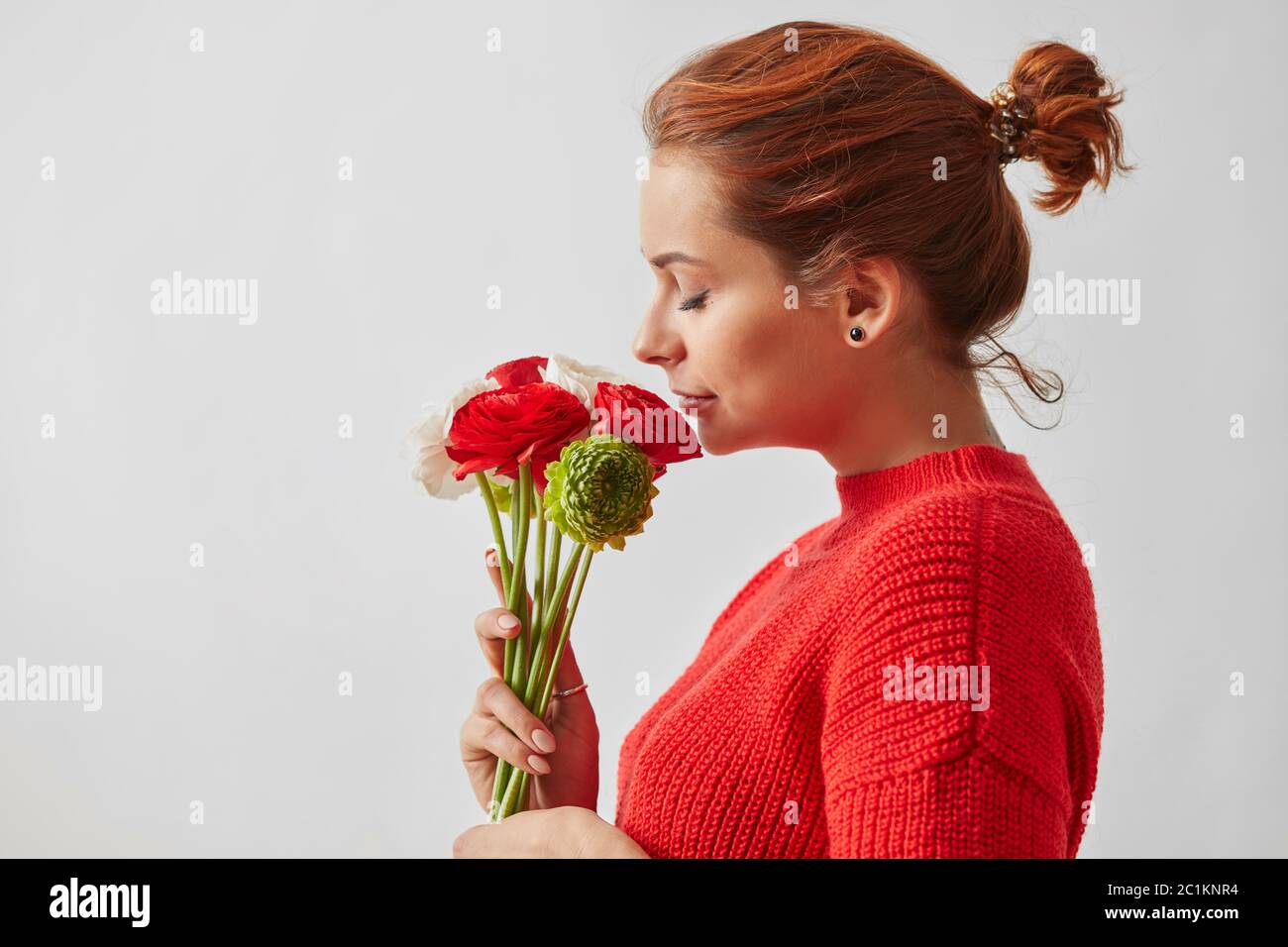 Beautiful girl in profile, smelling flowers of a rose on a white ...
