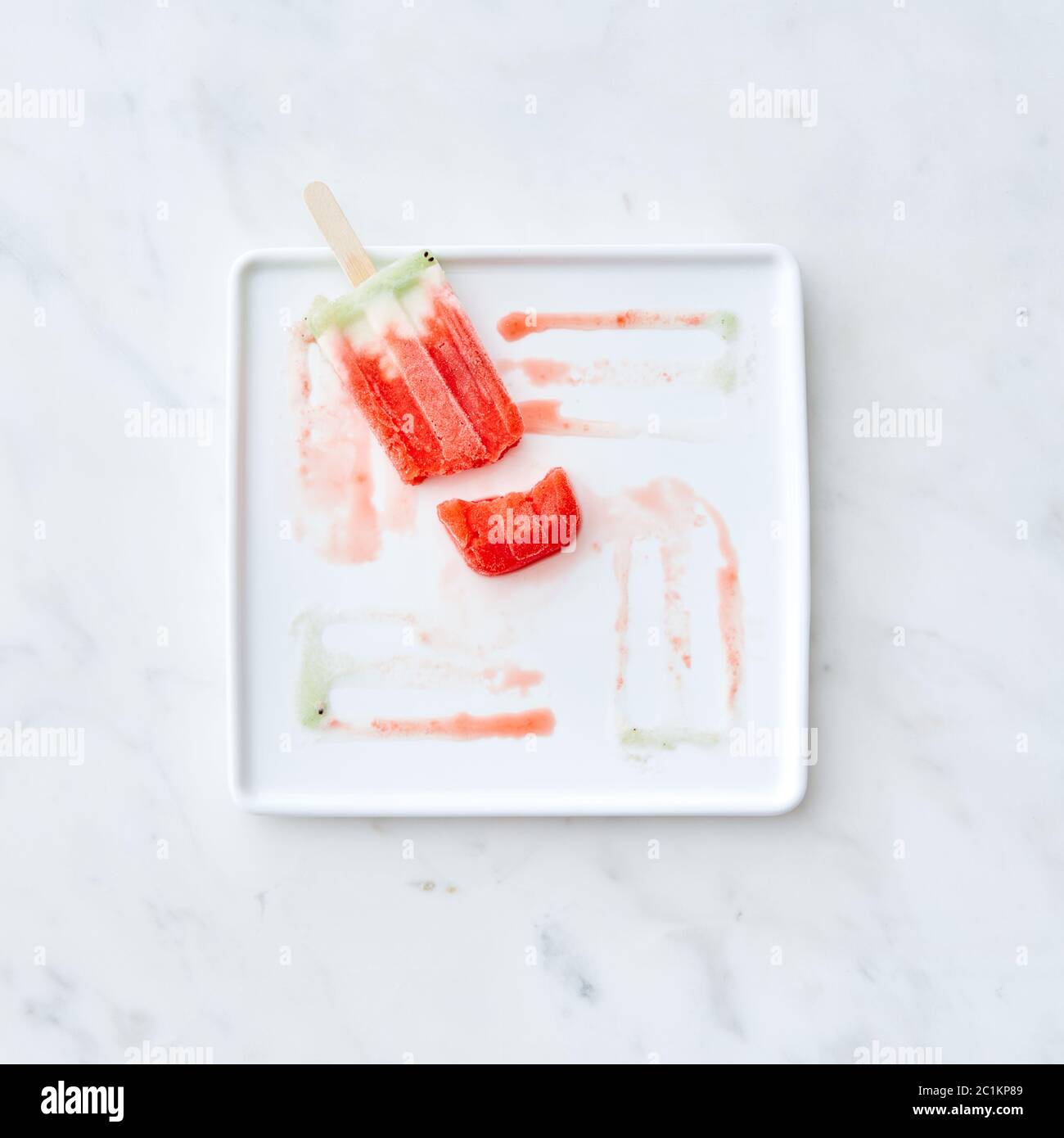 Broken fruit ice cream lolly on a white plate with a pattern from the ...