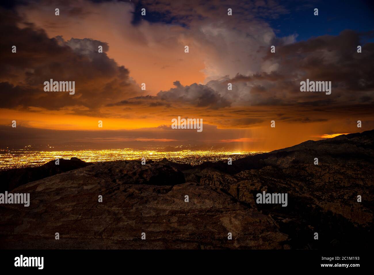 The city lights of Tucson glow at dusk during a full moon in September ...