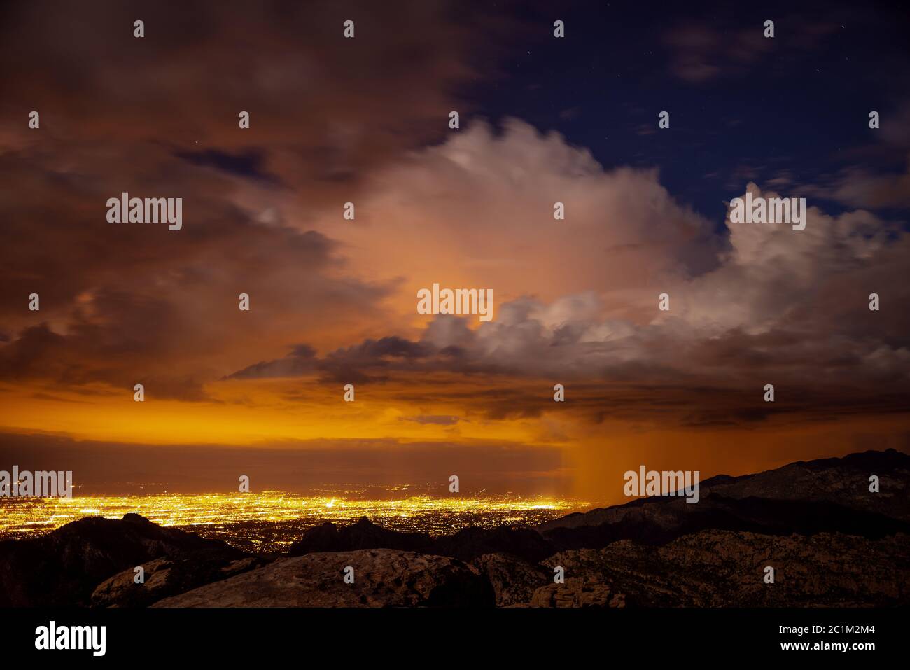 The city lights of Tucson glow at dusk during a full moon in September ...