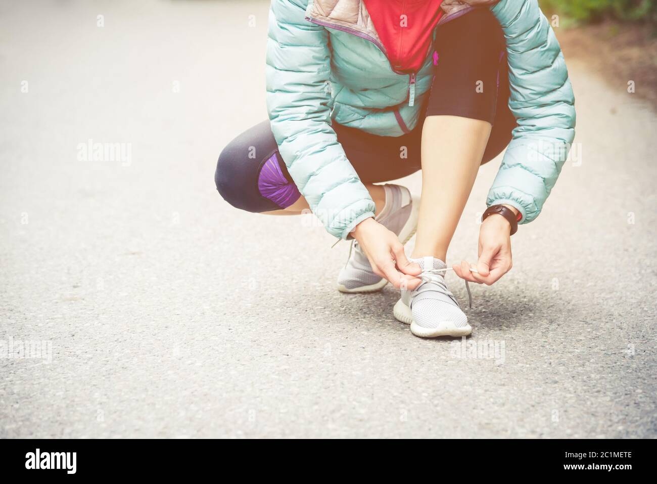 Girl runner tying laces for jogging her shoes on road in a park. Running shoes, Shoelaces ...