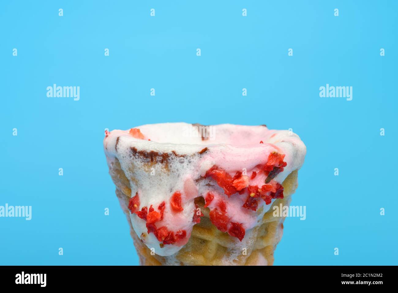 vanilla and strawberry flavor ice cream cone in a melting process on ...