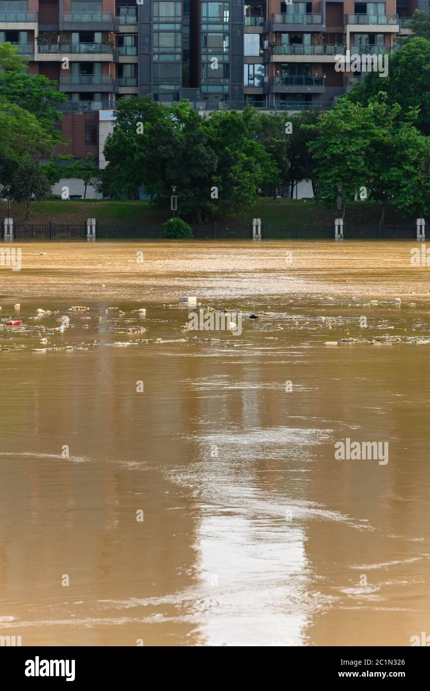 muddy flood with lots of man made trashes floating in a town vertical ...