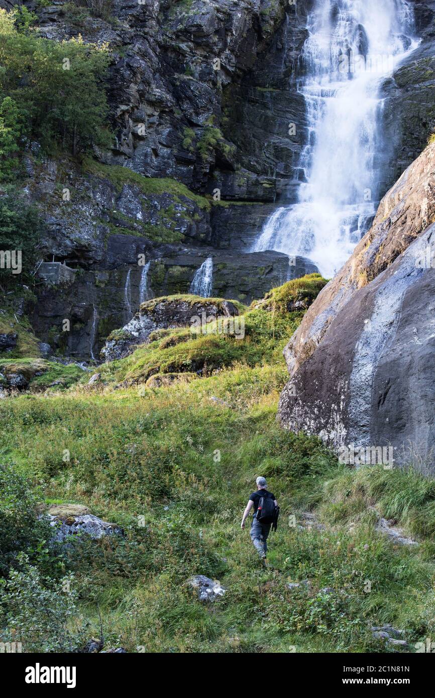 Hiker hiking with backpack looking at waterfall in park in beautiful ...