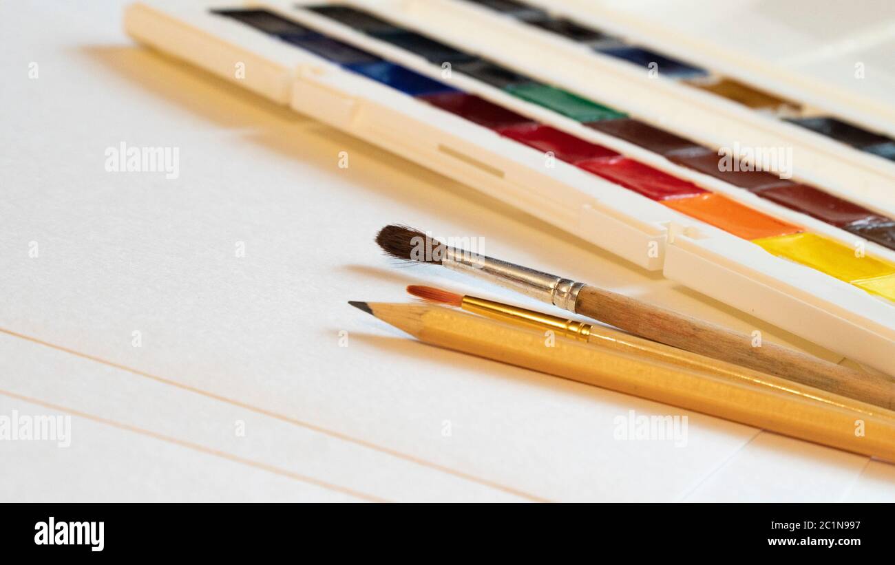 brush and pencil on the background of watercolor paints close-up side ...