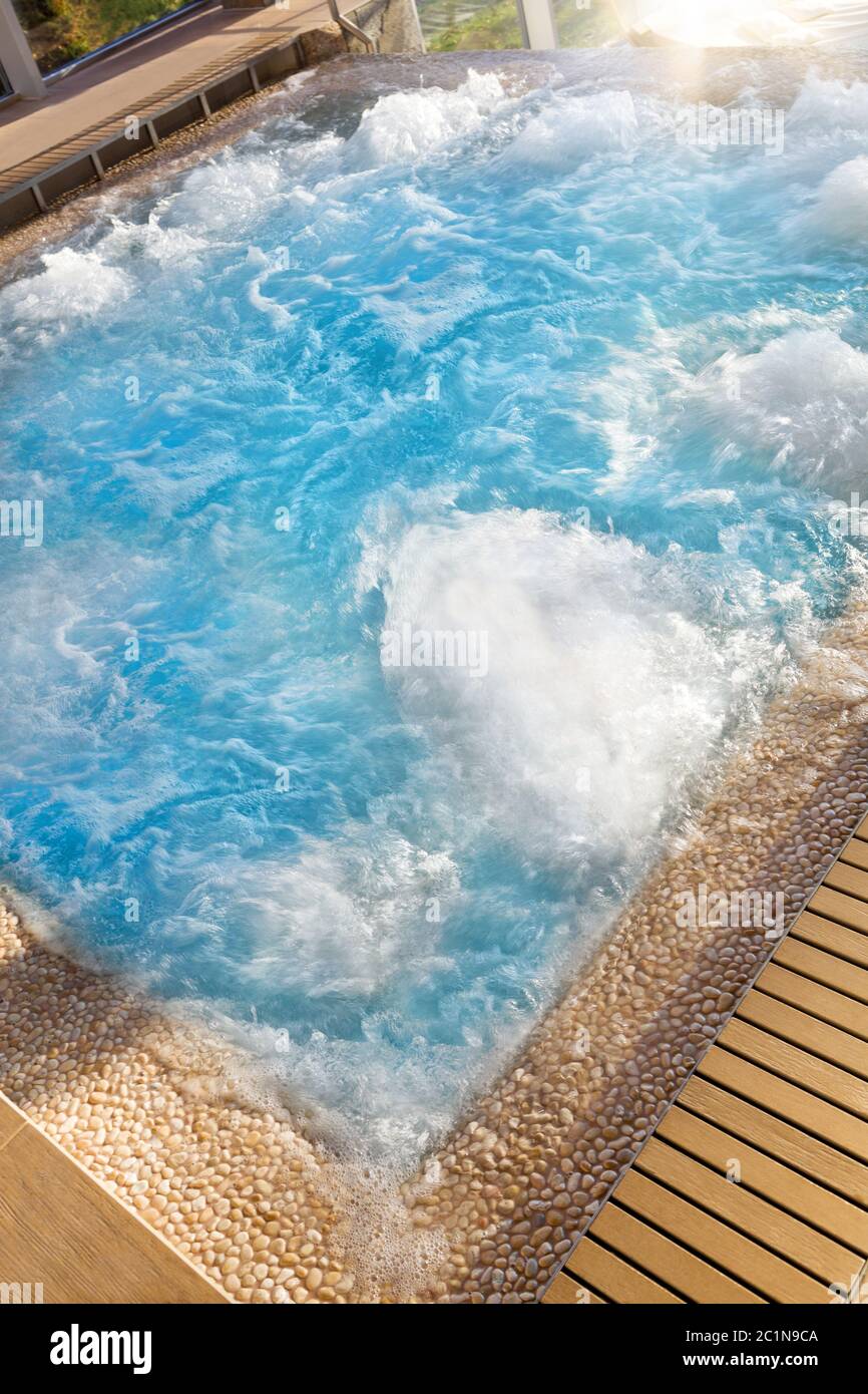Hot tub spa in luxurious hotel with big glass windows with nature view ...
