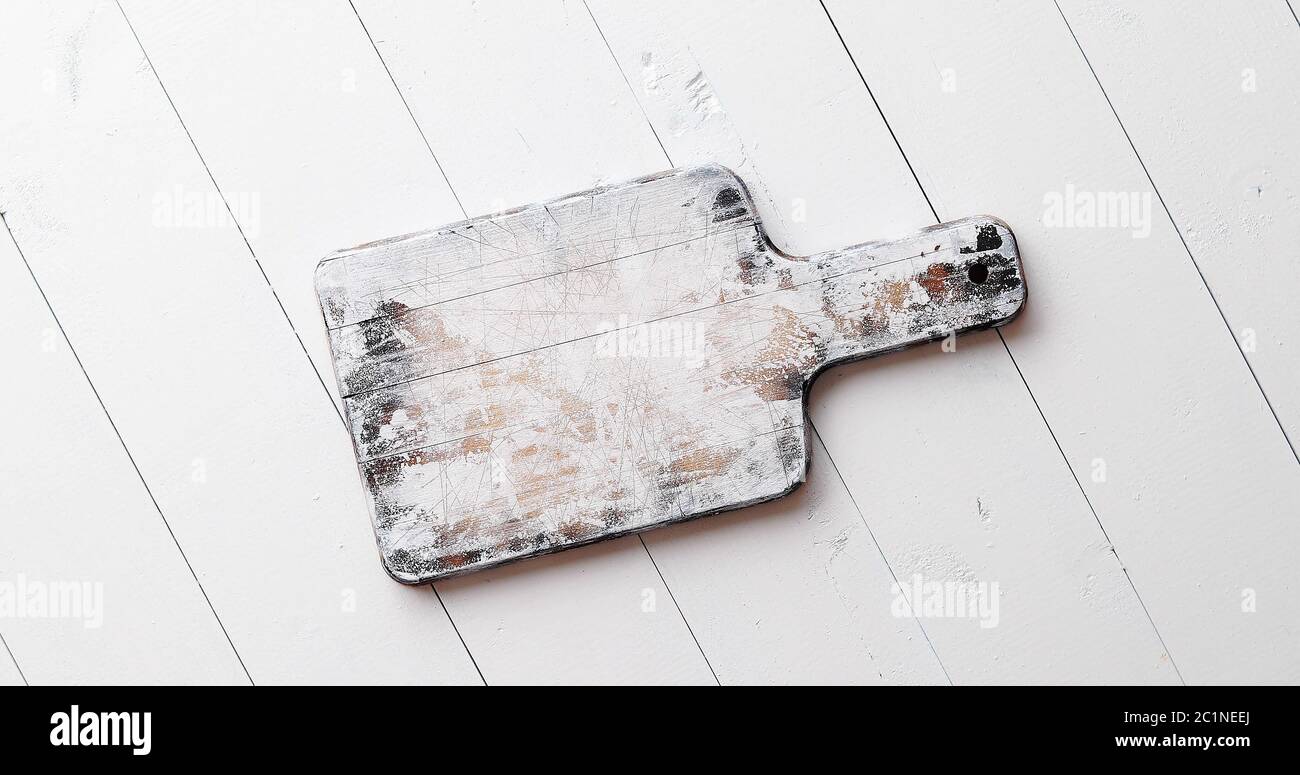 Wooden chopping board on white board table Stock Photo - Alamy