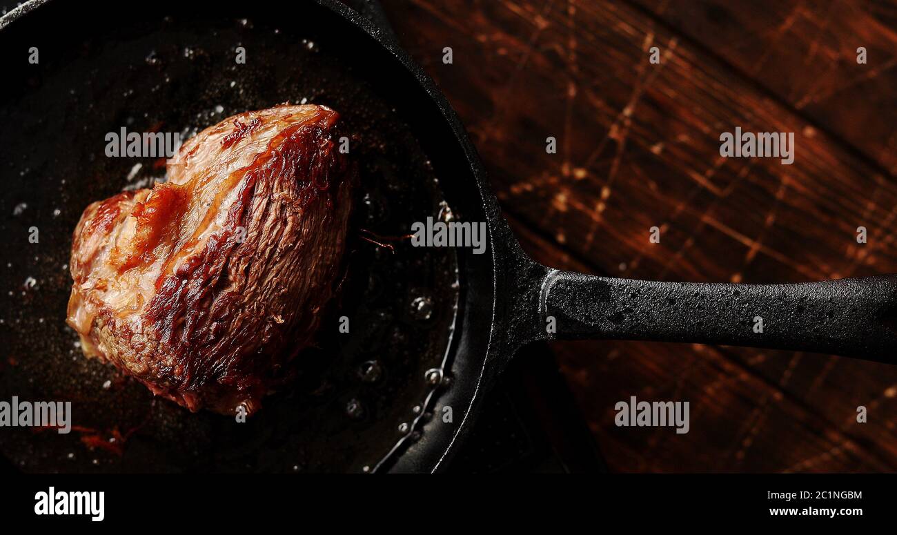 Skillet with roasted meat on table Stock Photo - Alamy