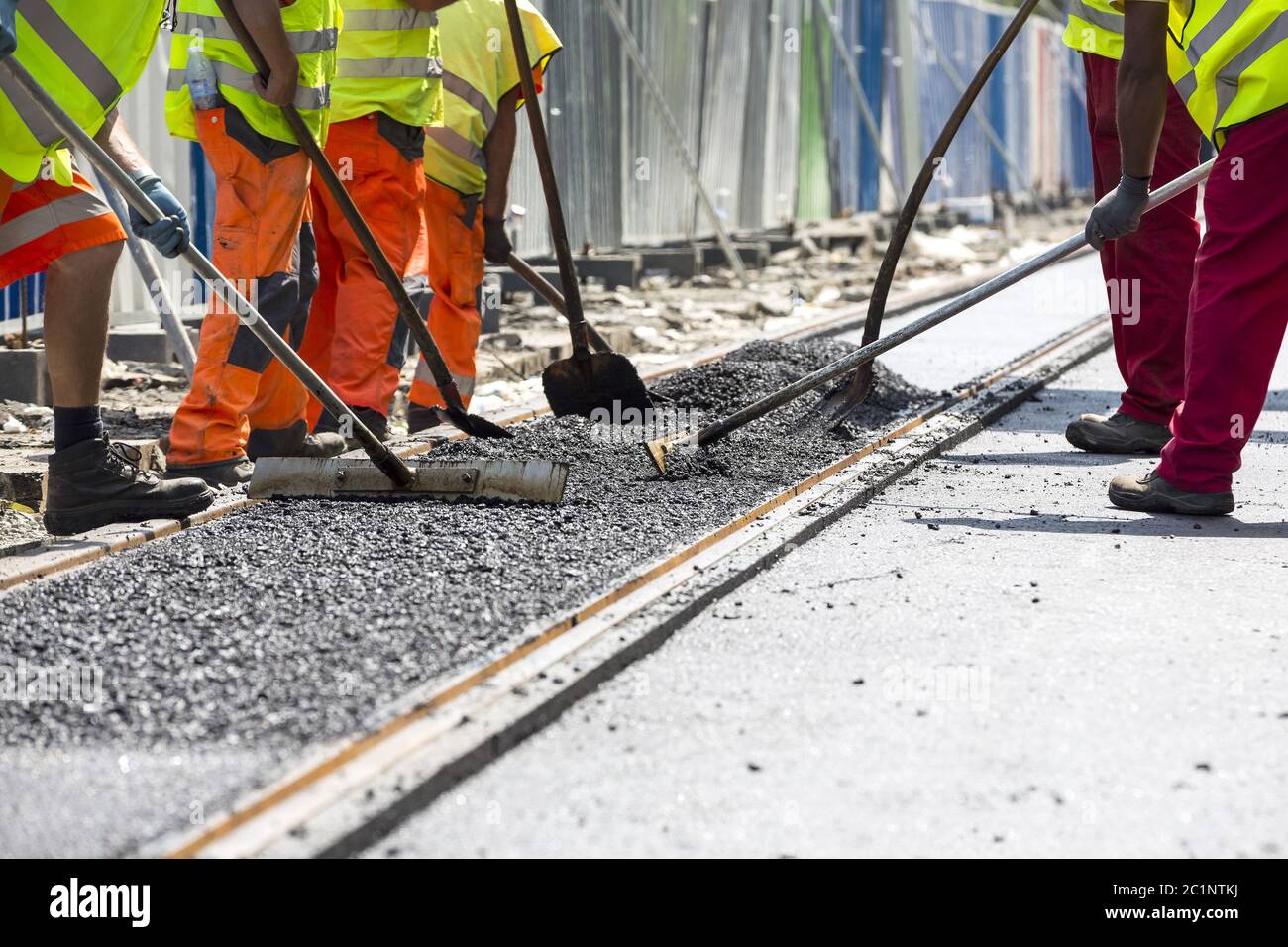 Workers construct asphalt road and railroad lines Stock Photo - Alamy