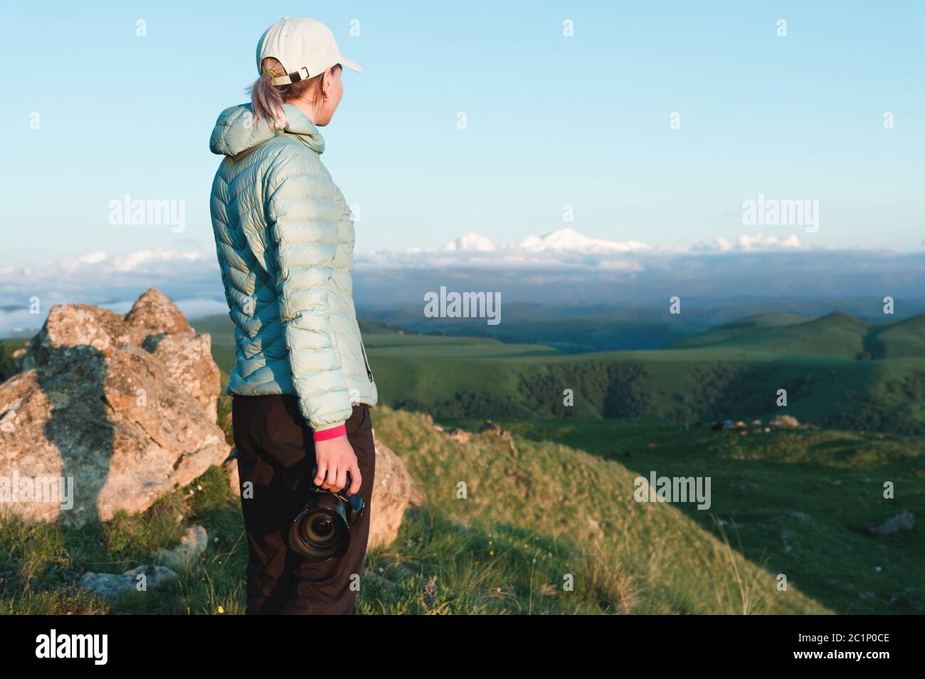 Portrait of a girl photographer in a cap in nature with a camera in ...