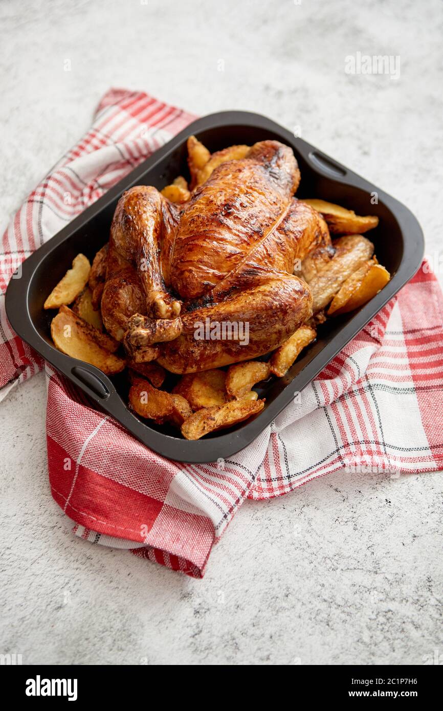 Roasted chicken or turkey with potatoes in black steel mold Stock Photo ...
