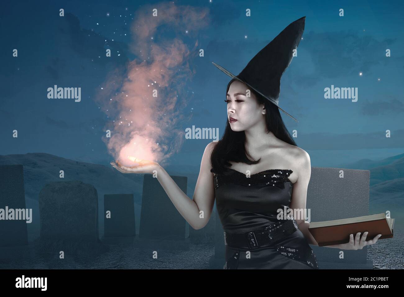 Asian witch woman with spellbook showing magic on her hand on the ...