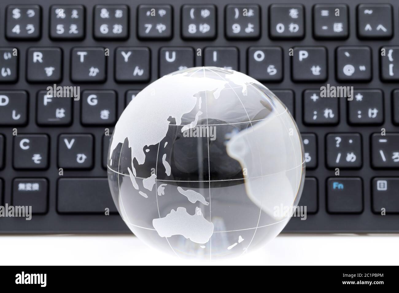 Glass globe ball with keyboard on white background Stock Photo - Alamy