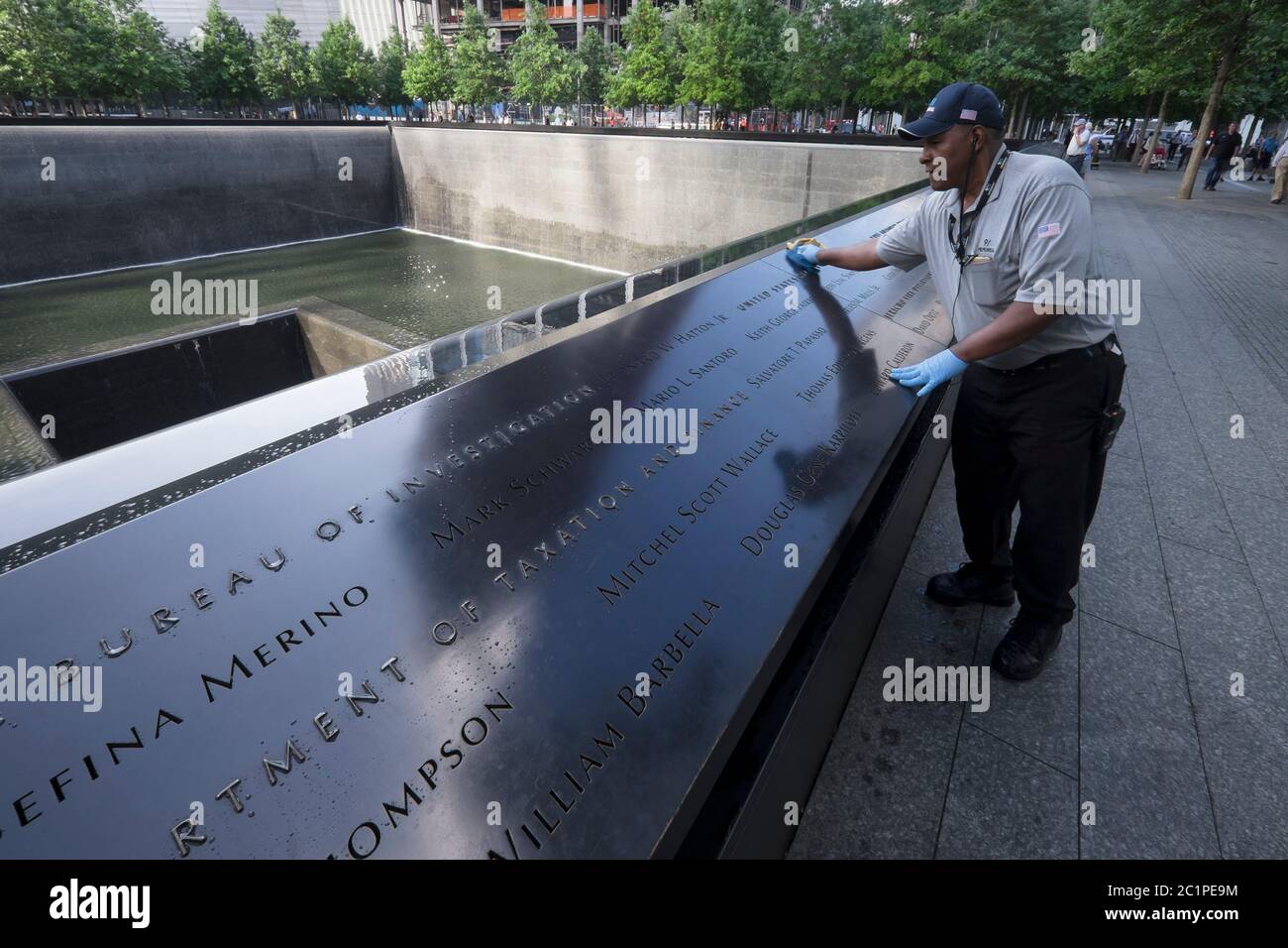 Man cleans the granite slab with names of the people who died in the ...