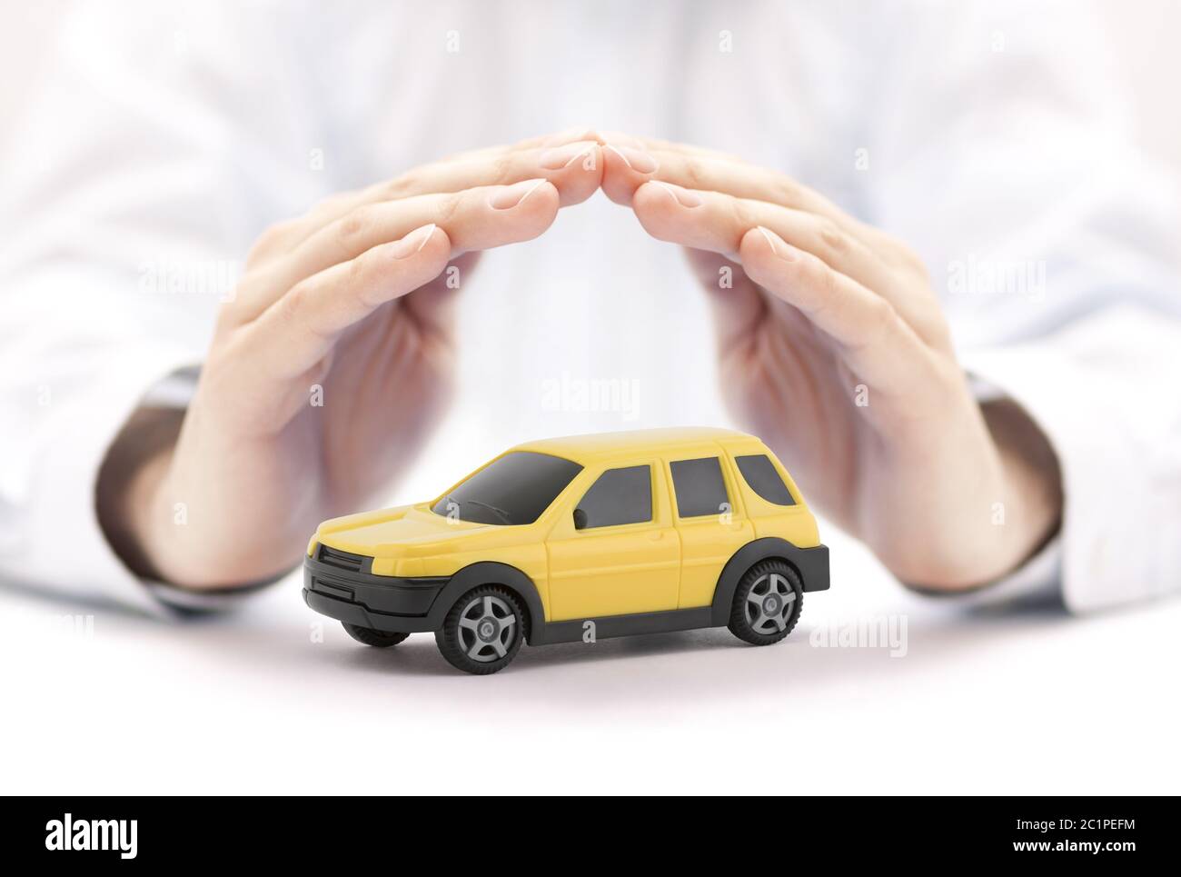 Car insurance concept with yellow car toy covered by hands Stock Photo ...