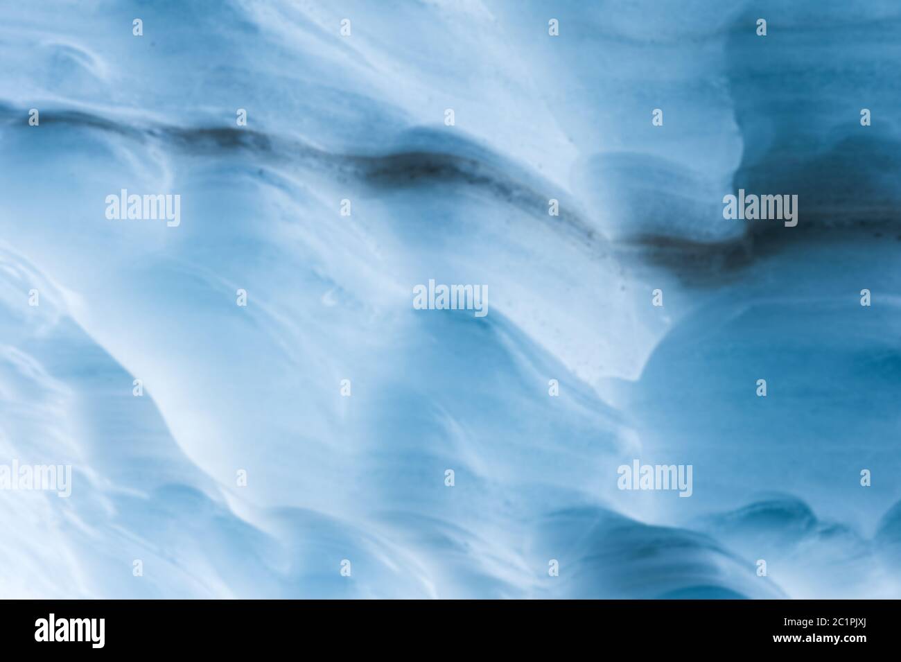 Close-up blurred wall of a centuries-old glacier with a structure of ...