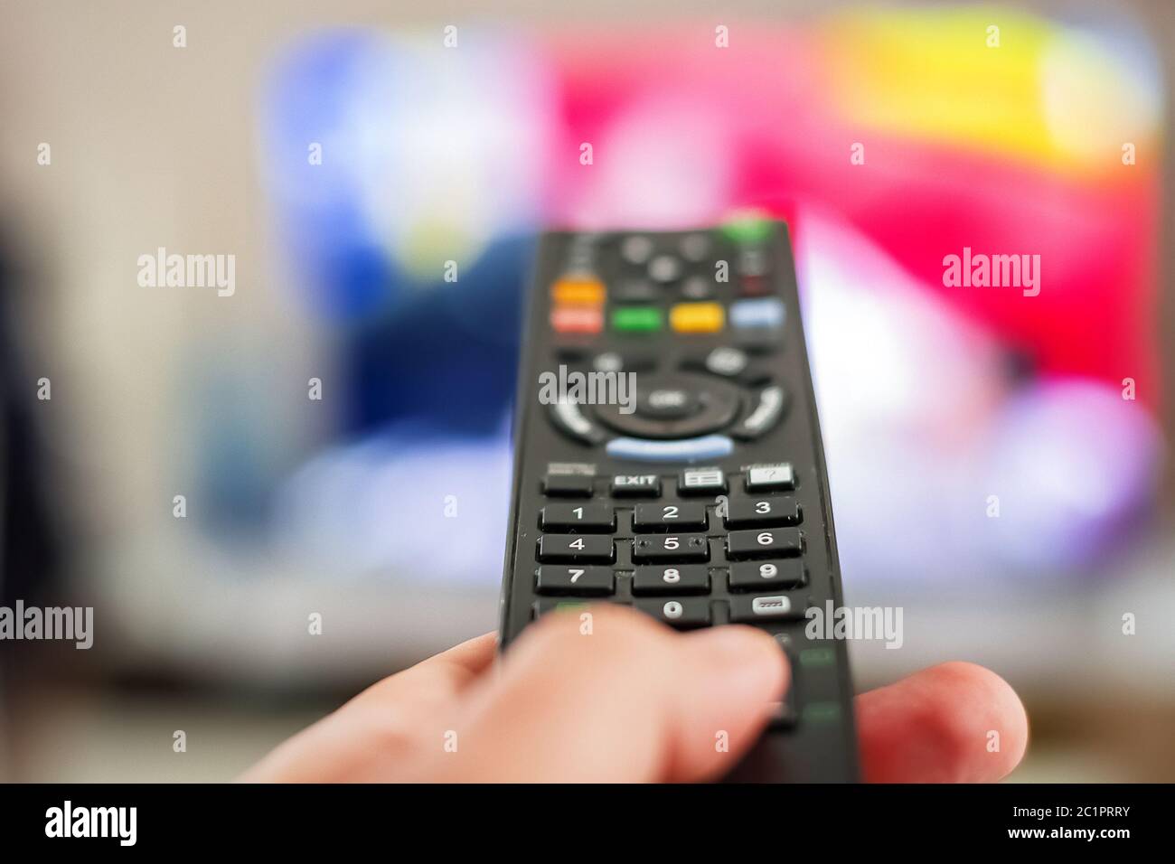 A hand pressing a television remote control button Stock Photo - Alamy