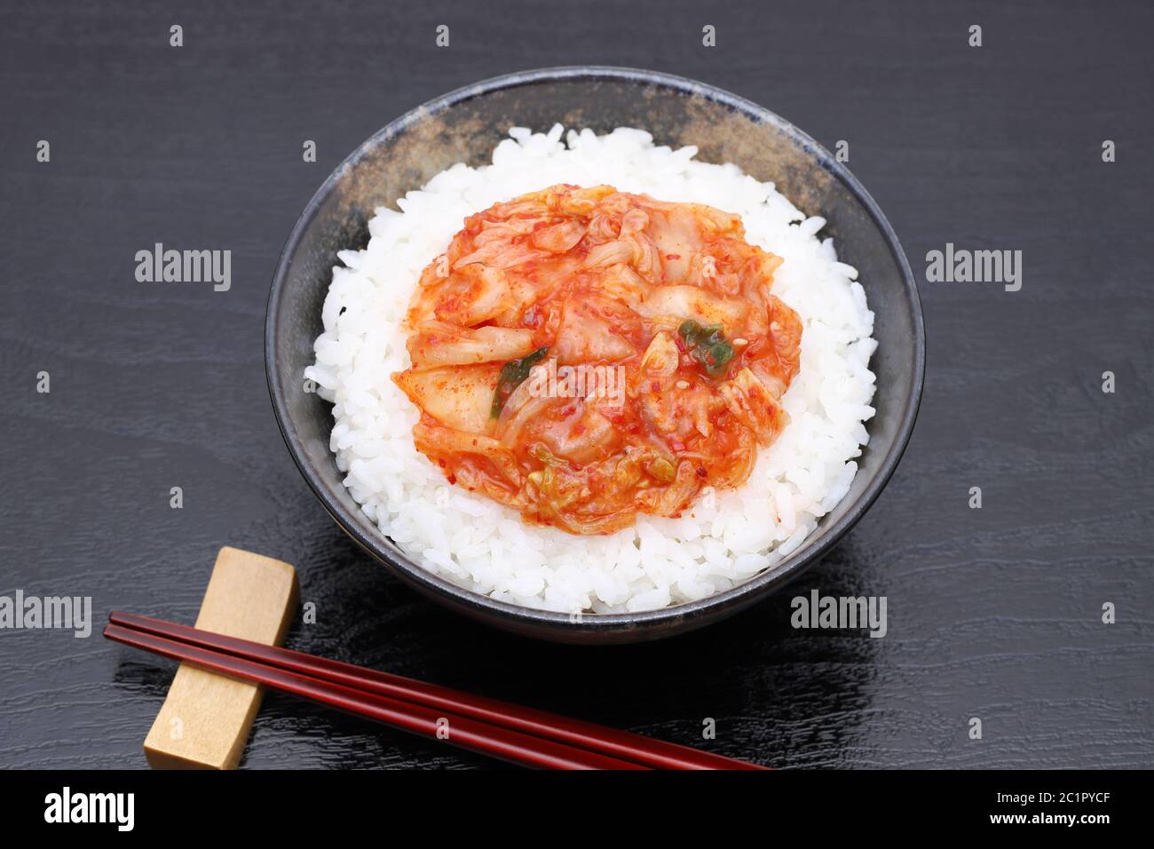 Korean cooked white rice with kimchi on black background Stock Photo ...