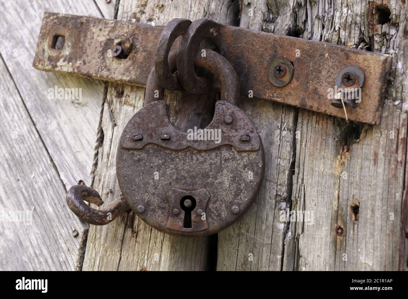 Old rusted lock on a rustic door with decorative natural weathered wood ...