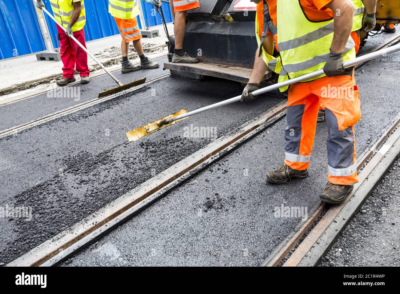 Workers construct asphalt road and railroad lines Stock Photo - Alamy