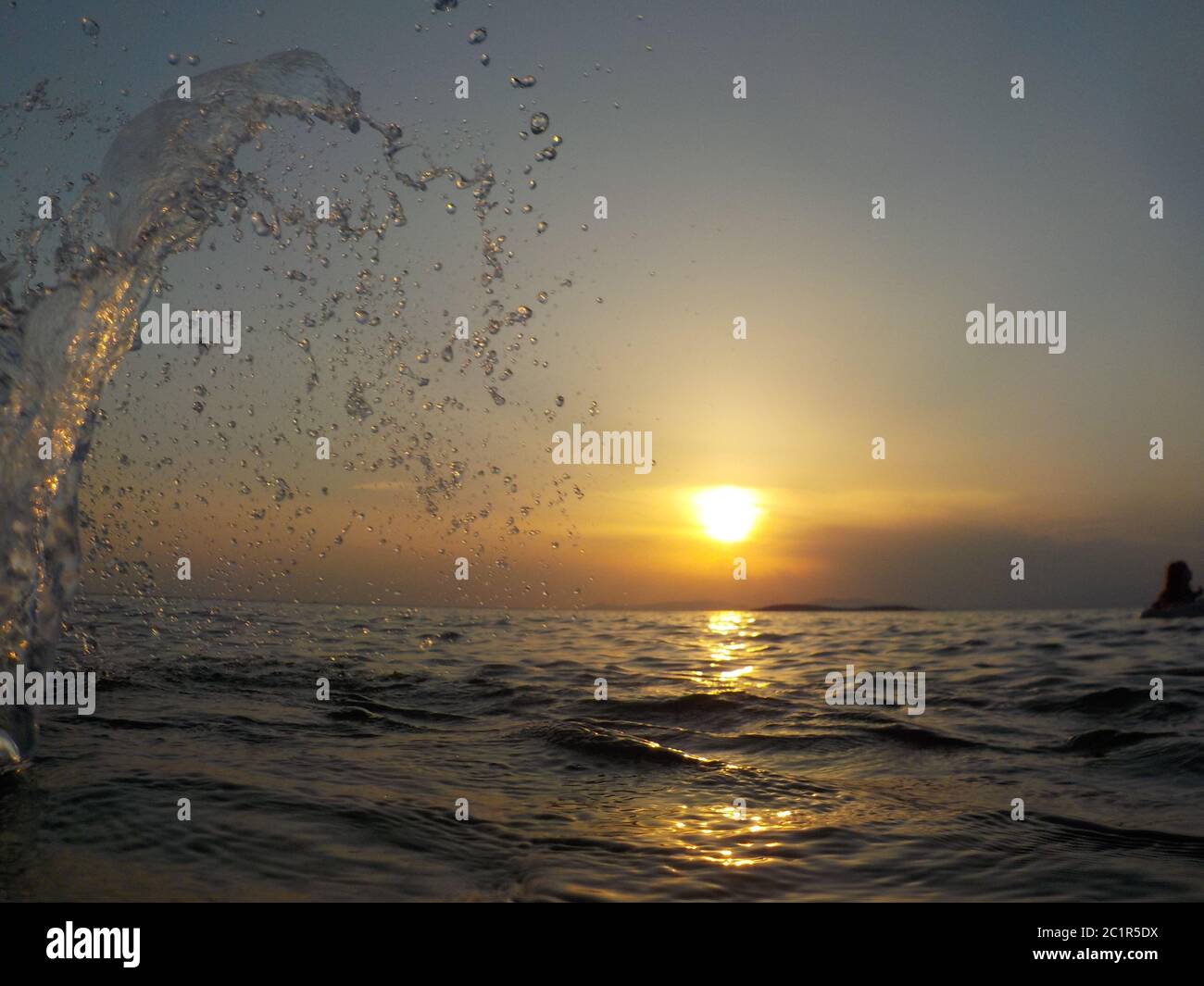 Silhouette of water splash at sunset, next to the sea Stock Photo - Alamy