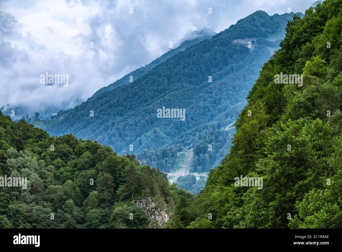 High mountain with green slopes hidden in thick clouds and fog. Heavy ...