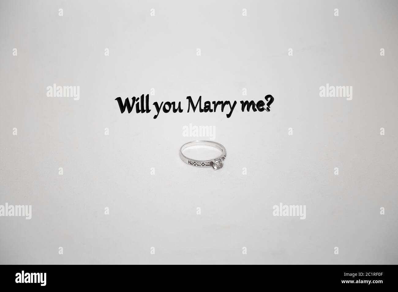 Silver engagement rings with the text will you marry me Stock Photo - Alamy