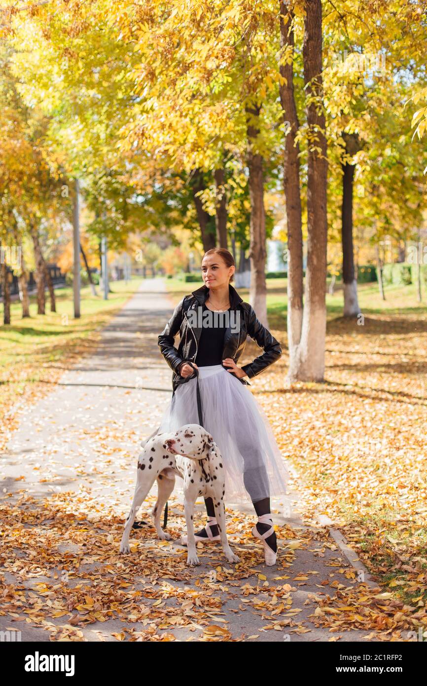 Ballerina with Dalmatian dog in the Park. Woman ballerina in a white ...