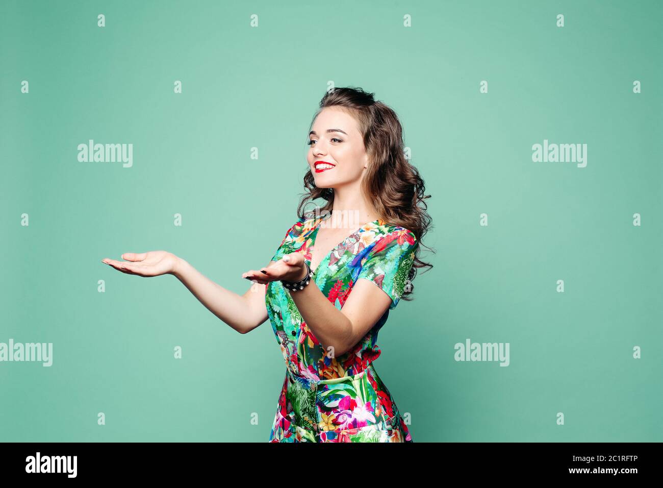 Lovely girl smiling away with outstretched arm demonstrating two ...