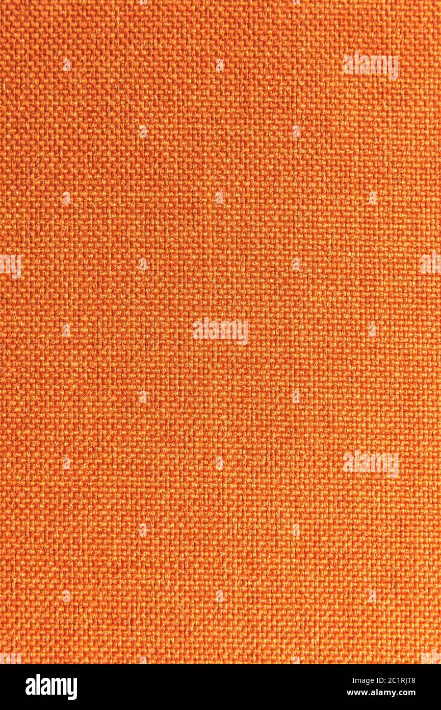 Textured background surface of textile upholstery furniture close-up. Orange color fabric ...