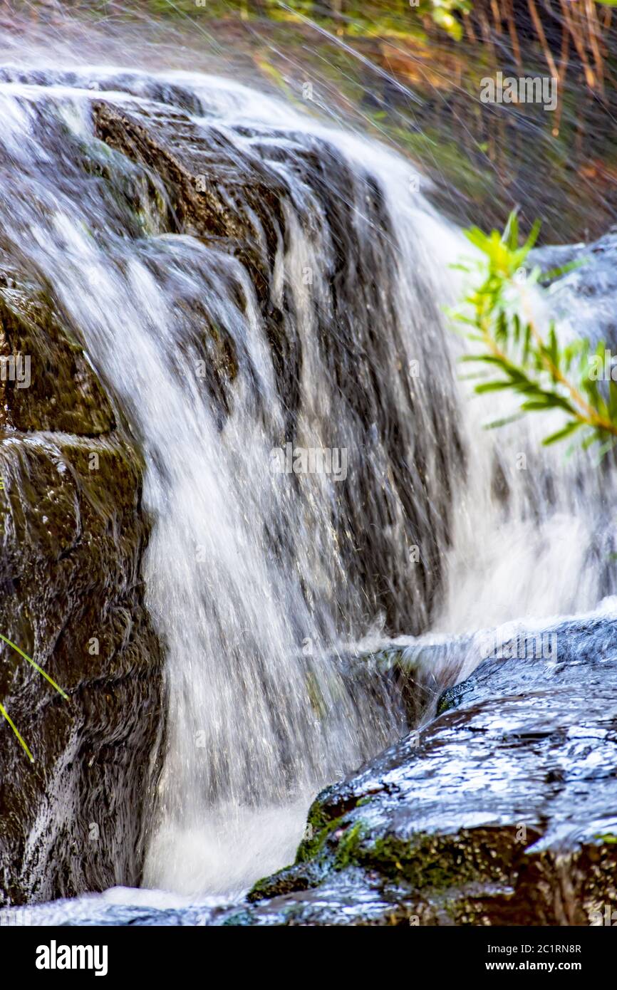 Small waterfall with water running over rocks Stock Photo - Alamy
