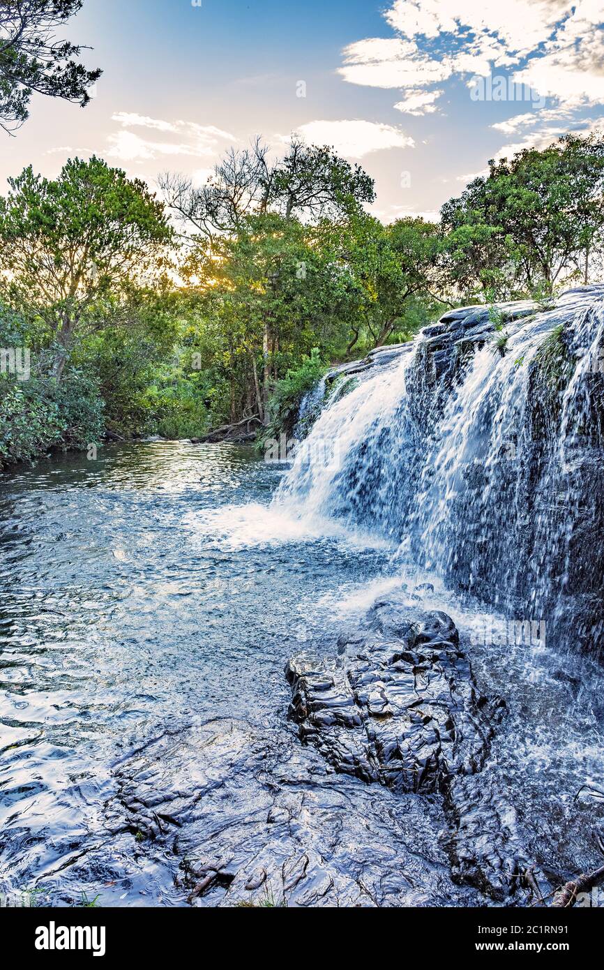 Small waterfall and river with water running over rocks Stock Photo - Alamy