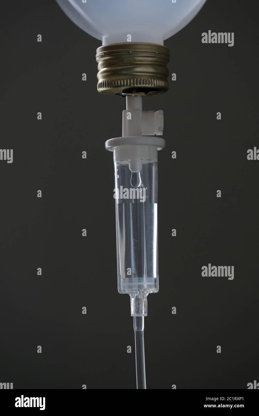Close up of a medical infusion system with drops at dark background ...