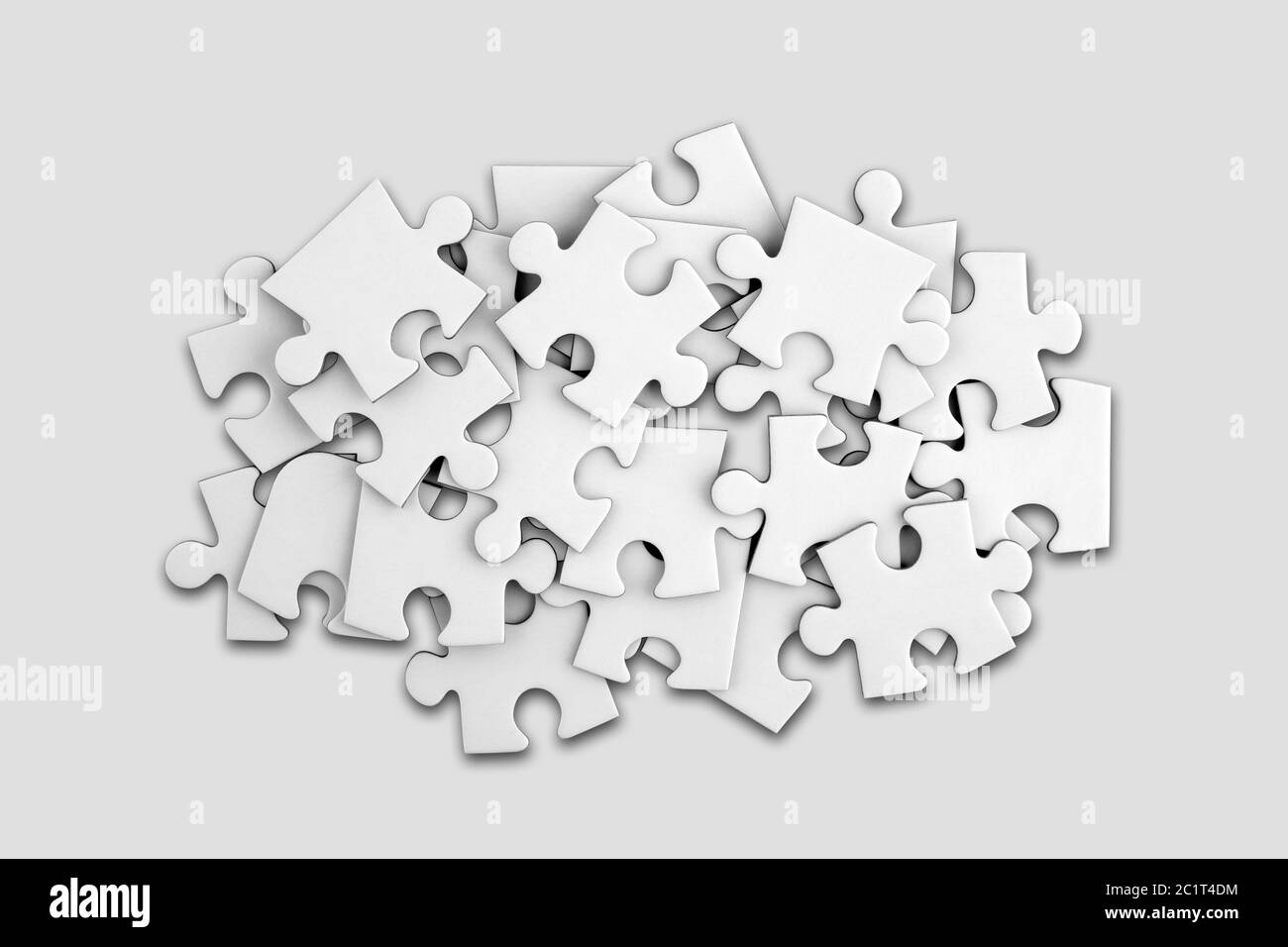 Small white puzzle pieces on gray background Stock Photo - Alamy