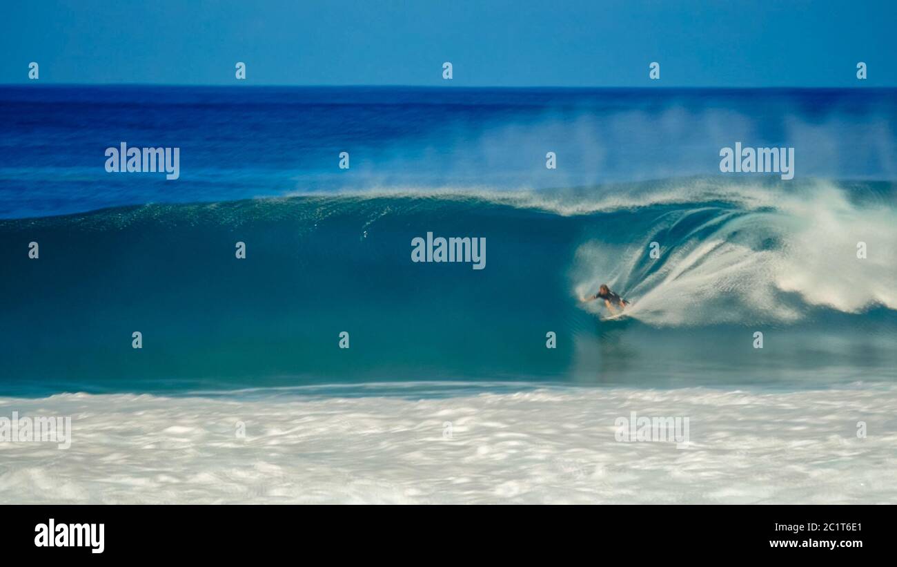 long exposure shot of surfer gets a tube ride at backdoor pipeline ...