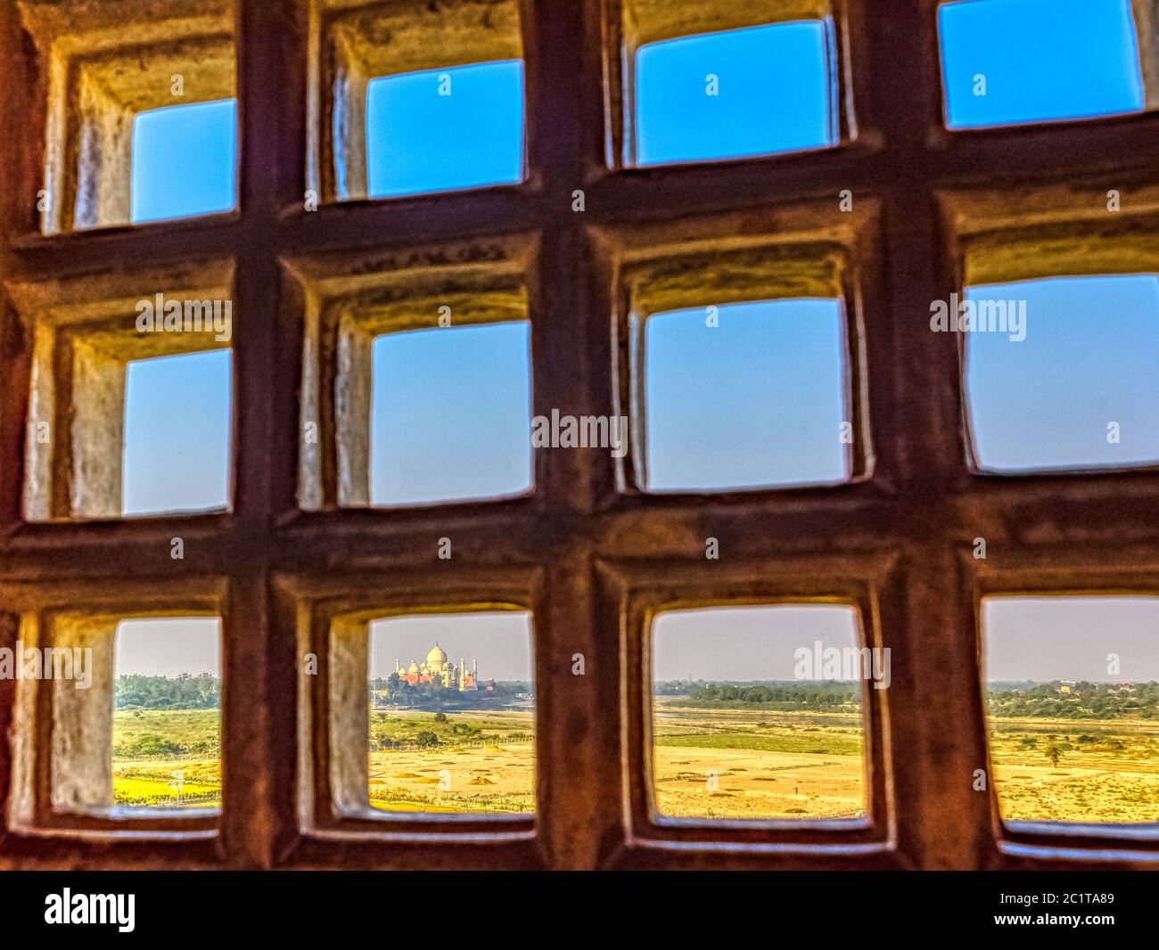 Taj Mahal behind bars - panoramic view of fields with Taj Mahal in ...