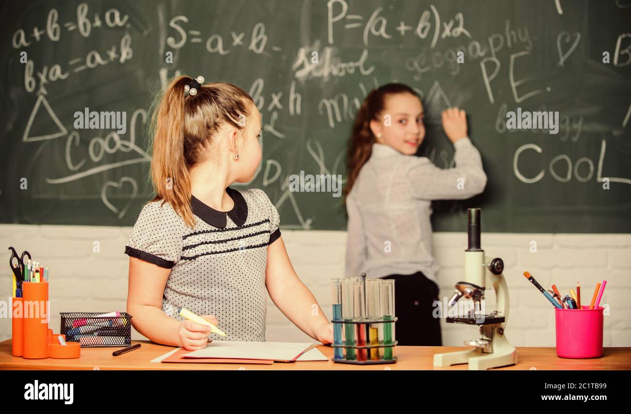 Educational experiment. Girls classmates study chemistry. Microscope ...