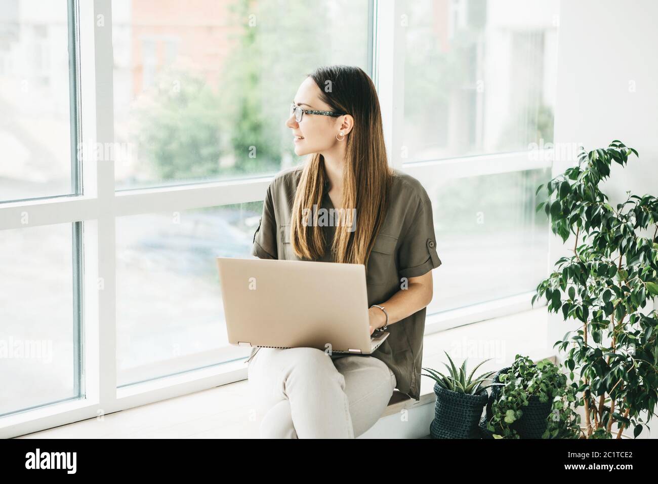 Beautiful young adult girl is using a computer. She is distracted and ...