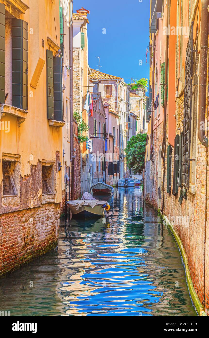 Venice cityscape with narrow water canal with boats moored between old ...