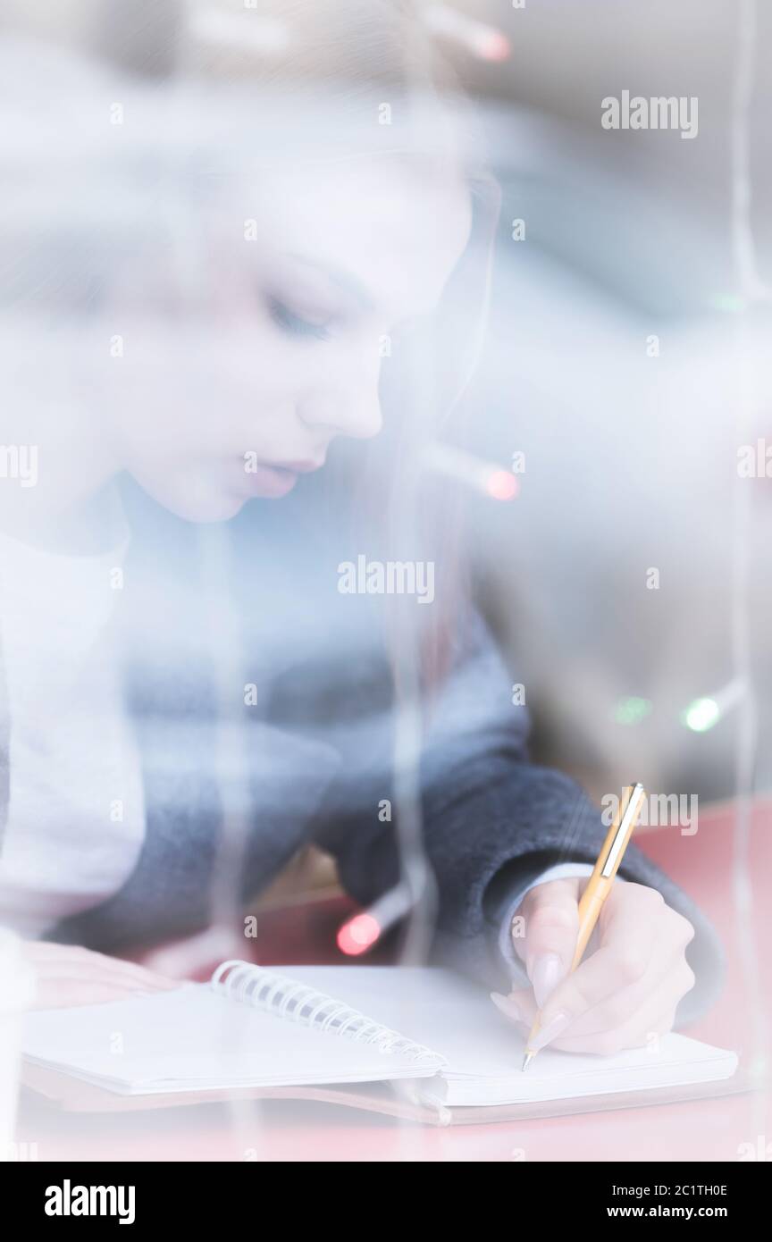 Portrait of an attractive young journalist girl with pen and notepad in ...