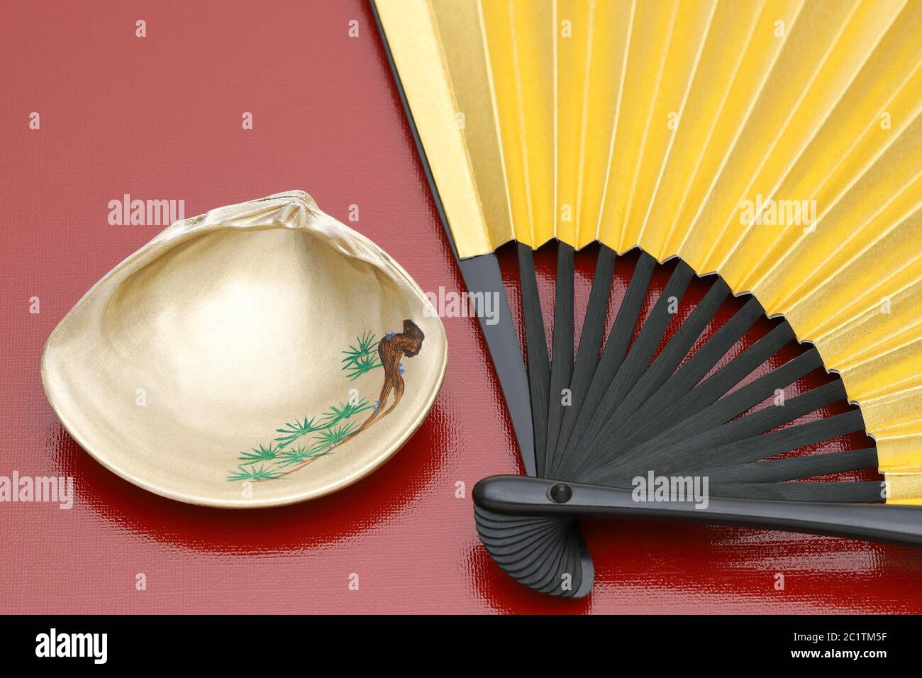Japanese golden folding fan and gold painting seashell on red ...